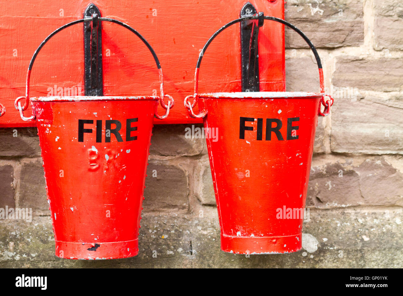 Two slightly battered hanging fire buckets Stock Photo - Alamy