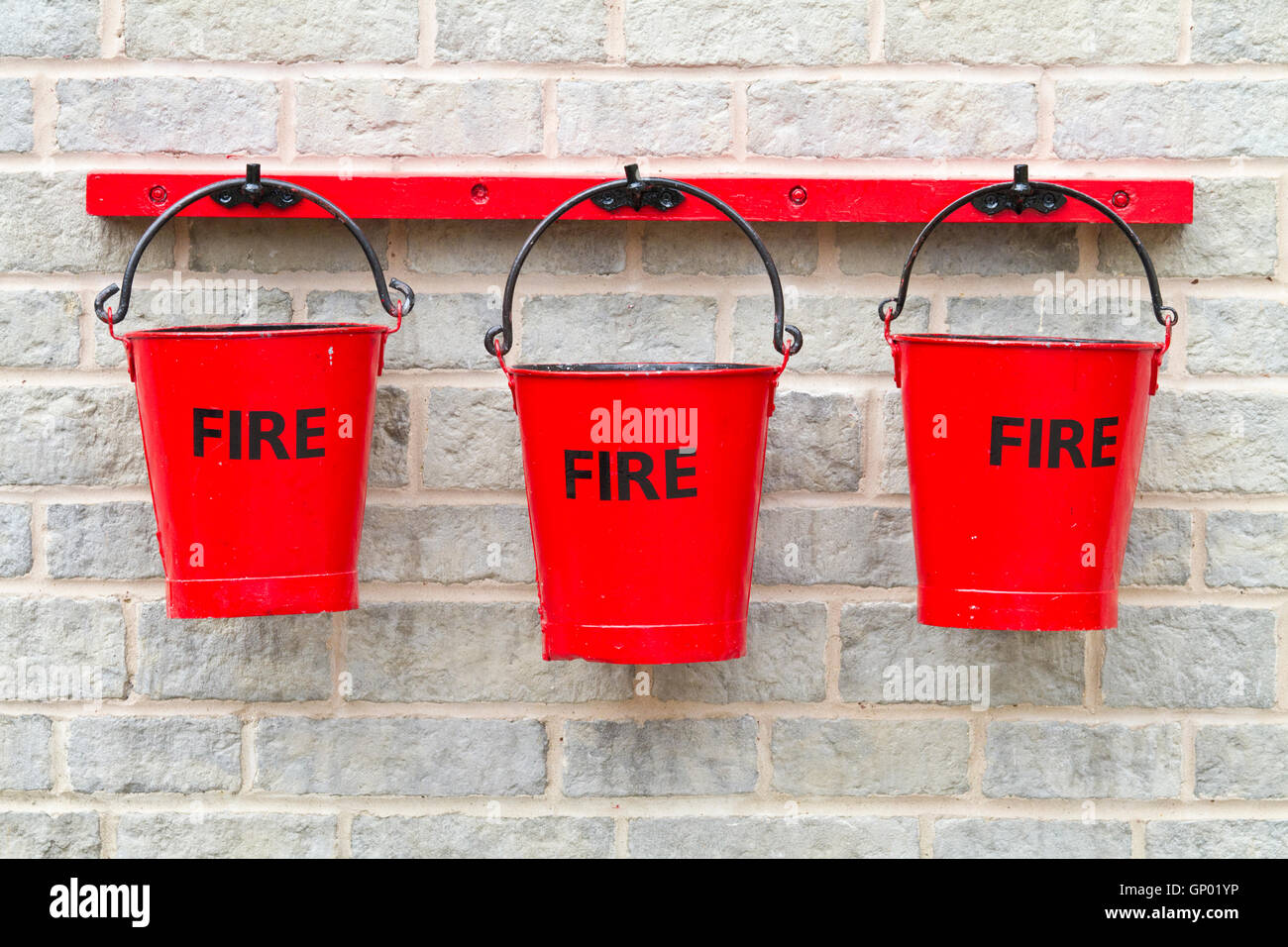 Three fire buckets hanging on a wall Stock Photo - Alamy