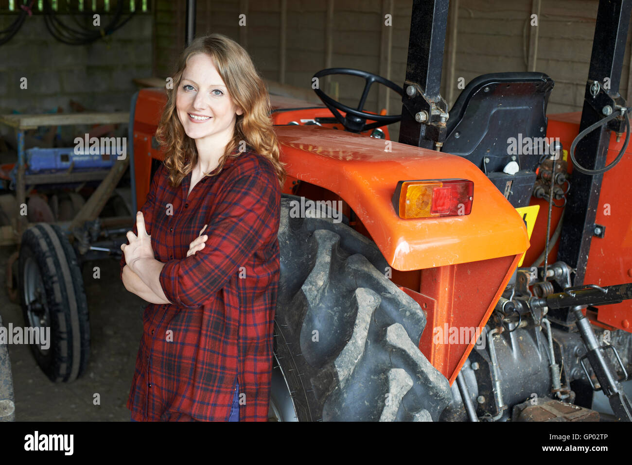 Portrait Of Female Agricultural Worker With Tractor Stock Photo - Alamy