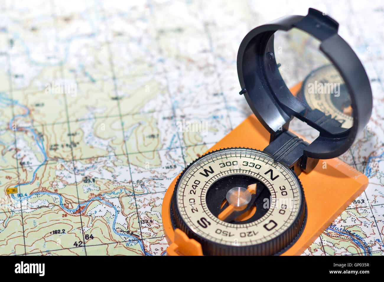 Compass & map - friends travelers. Magnetic compass on a topographic ...
