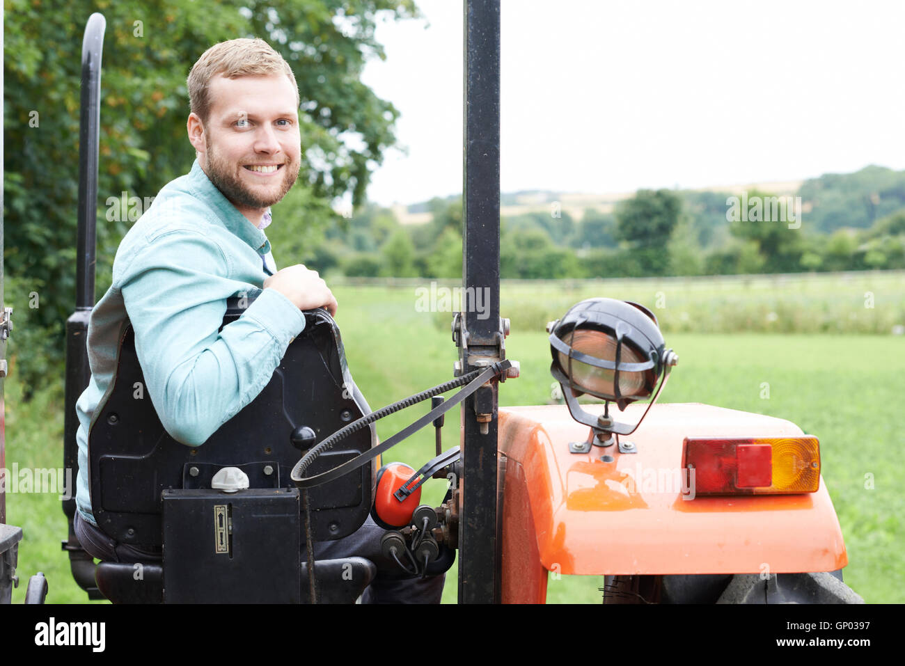Portrait Of Farmer Sitting On Tractor In Field Stock Photo - Alamy