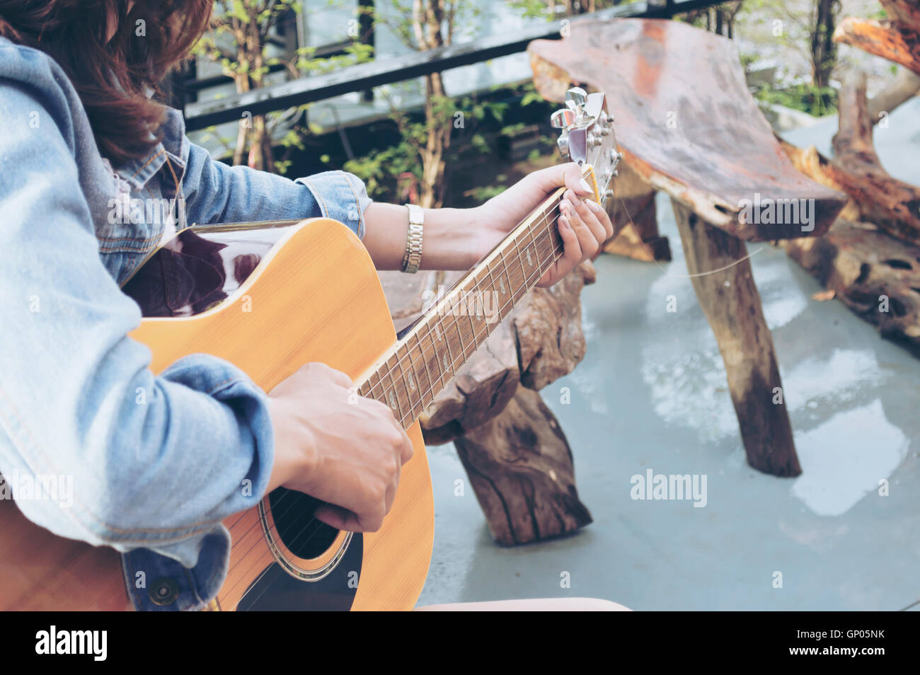 Asian woman playing guitar on wood table Stock Photo - Alamy