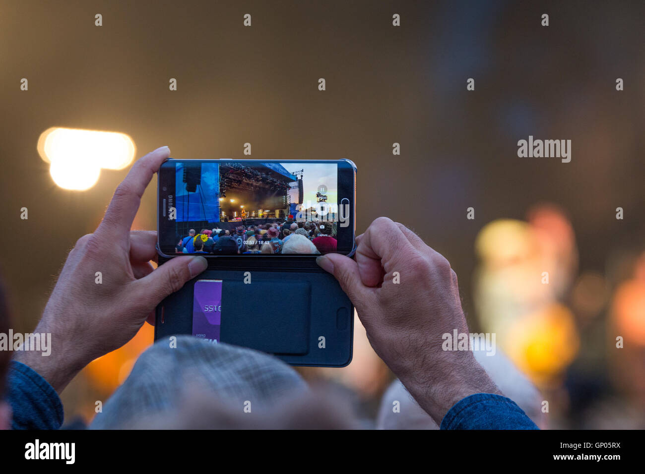 Picture of audience member watching a concert through their mobile ...