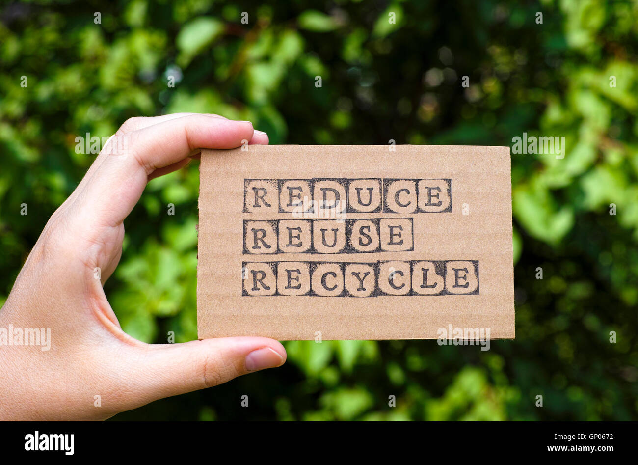 Woman hand holding cardboard card with words Reduce Reuse Recycle made ...