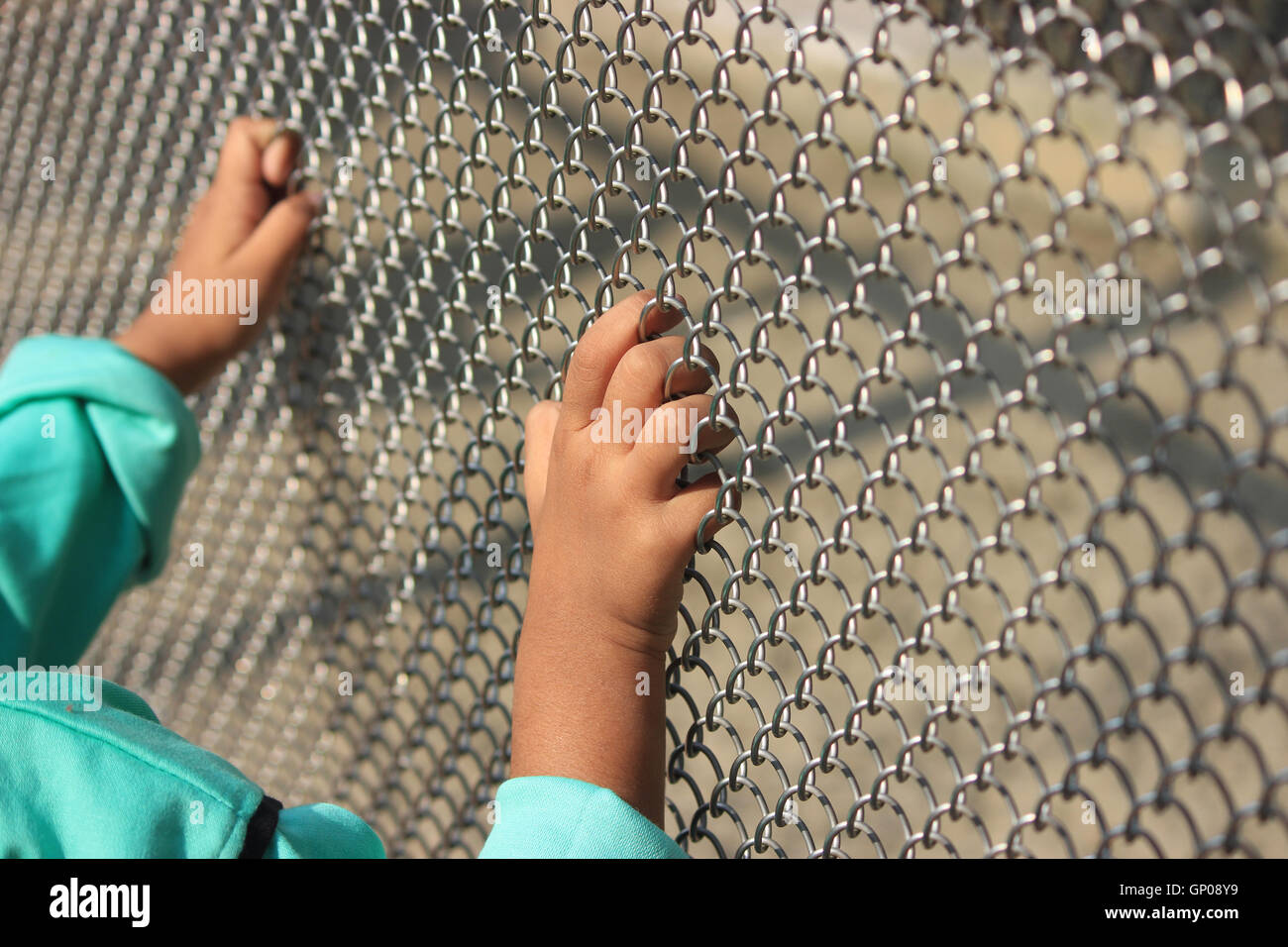 A child is in the cage. His hand is on the iron net Stock Photo - Alamy