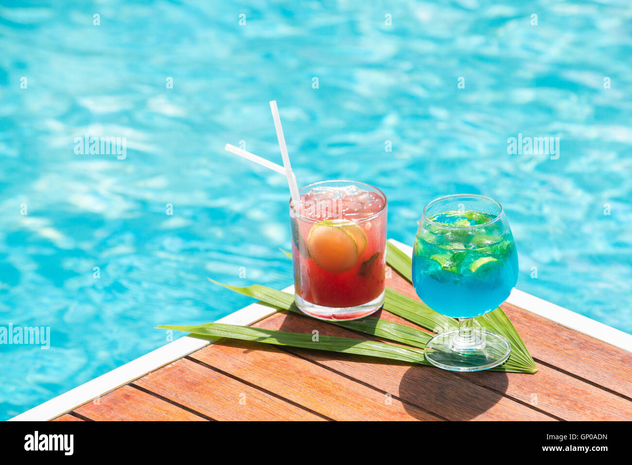 Cocktail glasses at pool, beach side. copy space Stock Photo - Alamy
