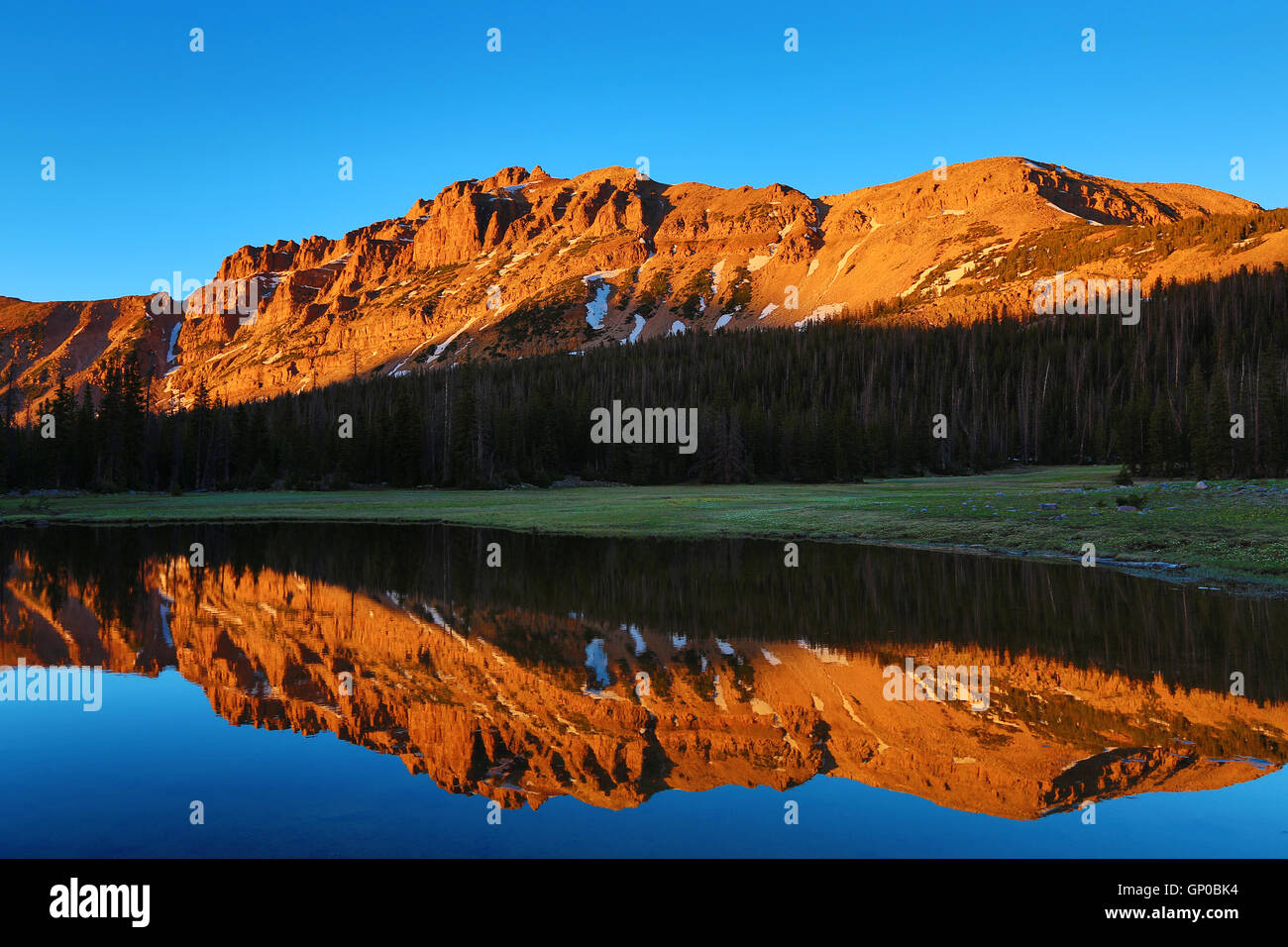 Hayden Peak and the Uinta Mountains are reflected in a small lake along ...