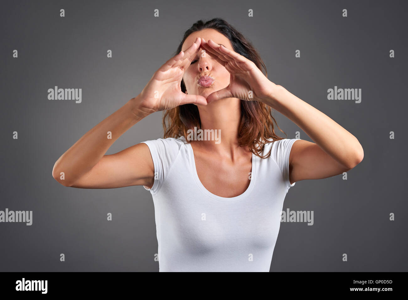 A beautiful young woman shaping a triangle with her hands sending a ...
