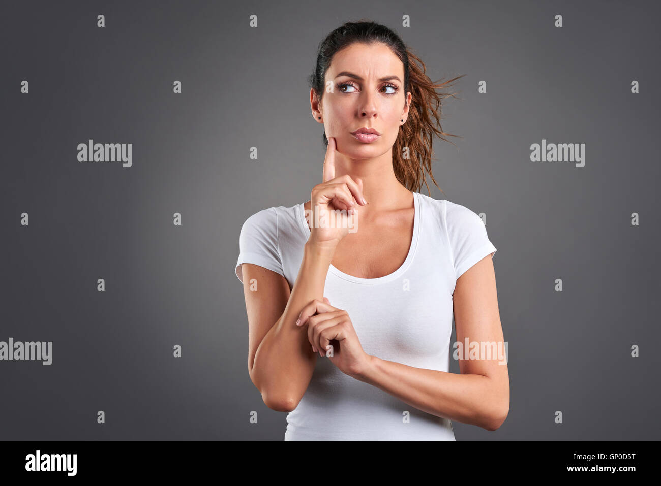 A beautiful young woman feeling and looking suspiciously Stock Photo ...