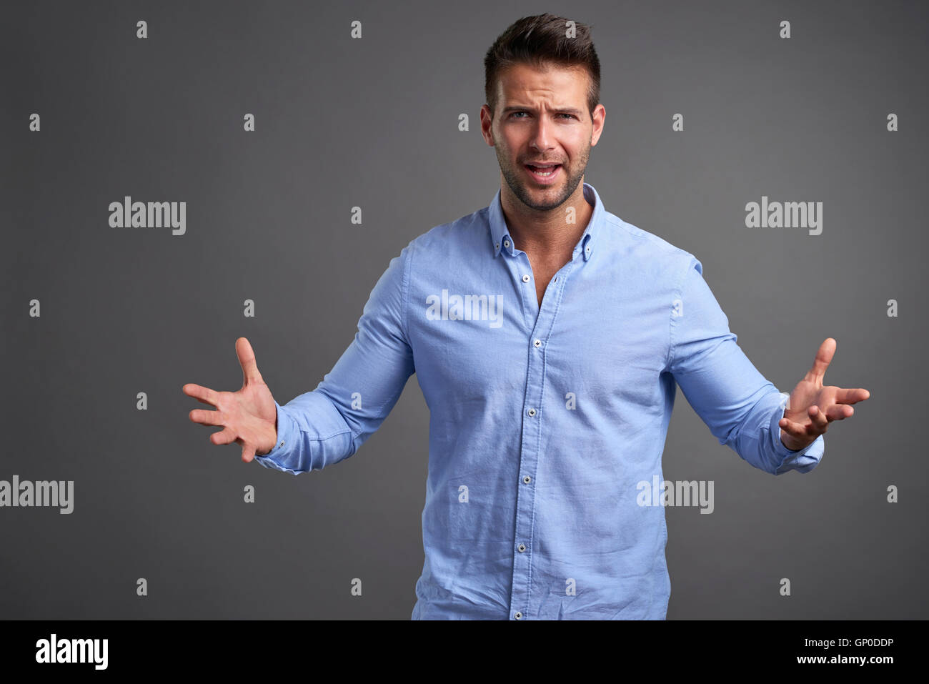 A handsome young man looking uncomprehendingly in to the camera in ...