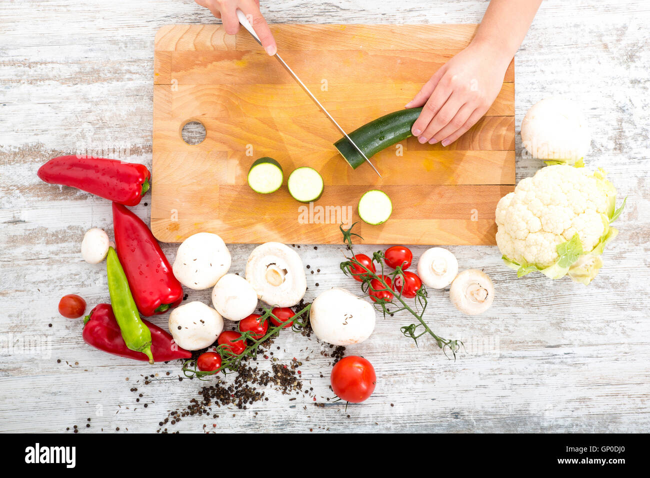 A woman chopping up vegetables at a table Stock Photo - Alamy