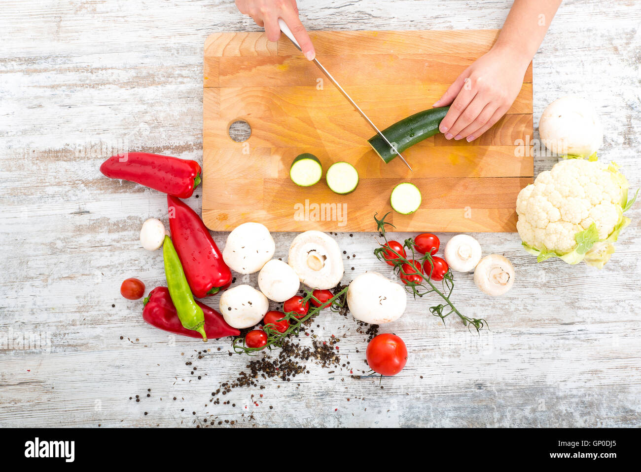 A woman chopping up vegetables at a table Stock Photo - Alamy