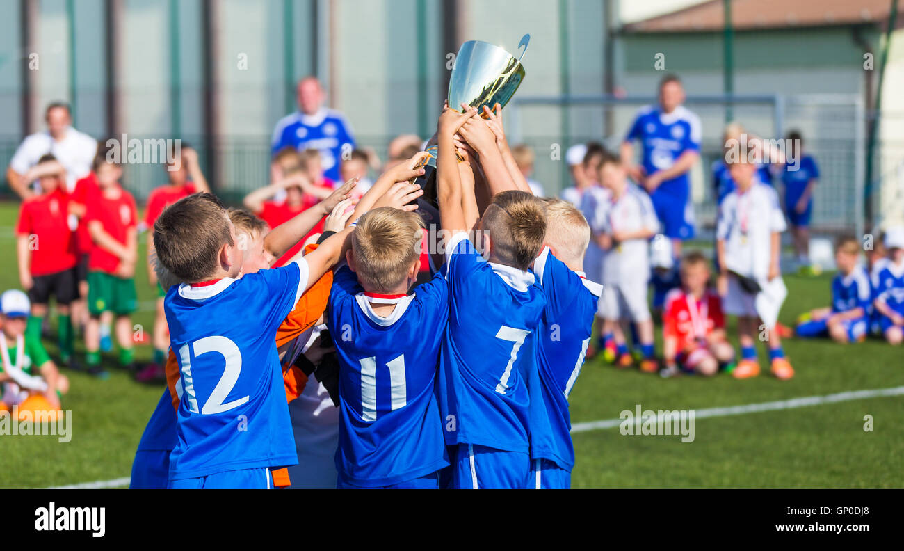 Young Soccer Players Holding Trophy. Boys Celebrating Soccer Football Championship. Winning team ...