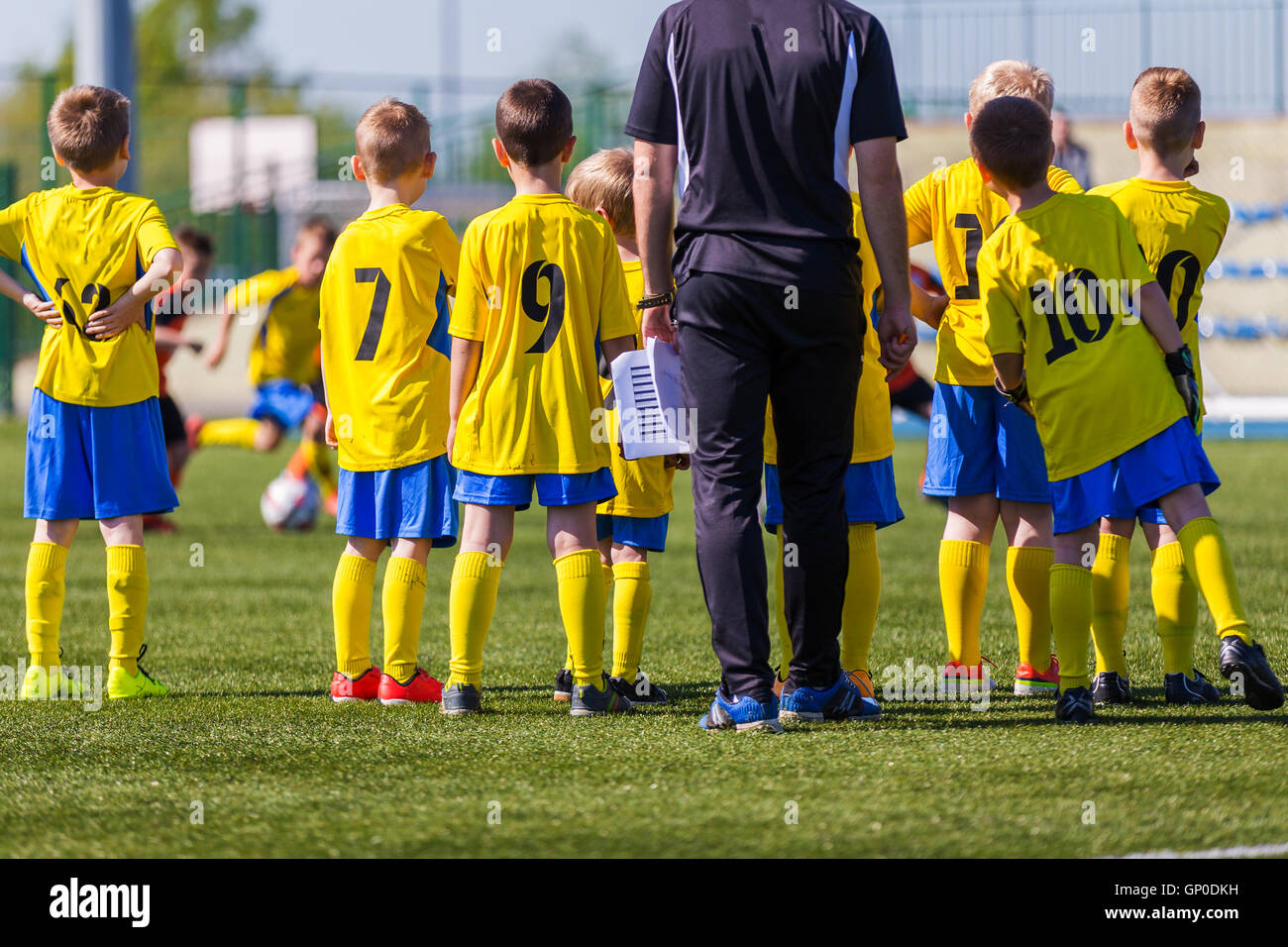 Coach and youth soccer reserve players watching football match. Coach ...