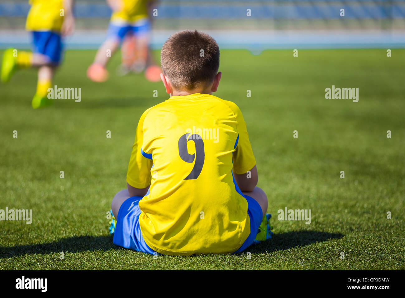 Young Boy Wearing Sport Outfit. Youth Soccer Player sitting on sports ...