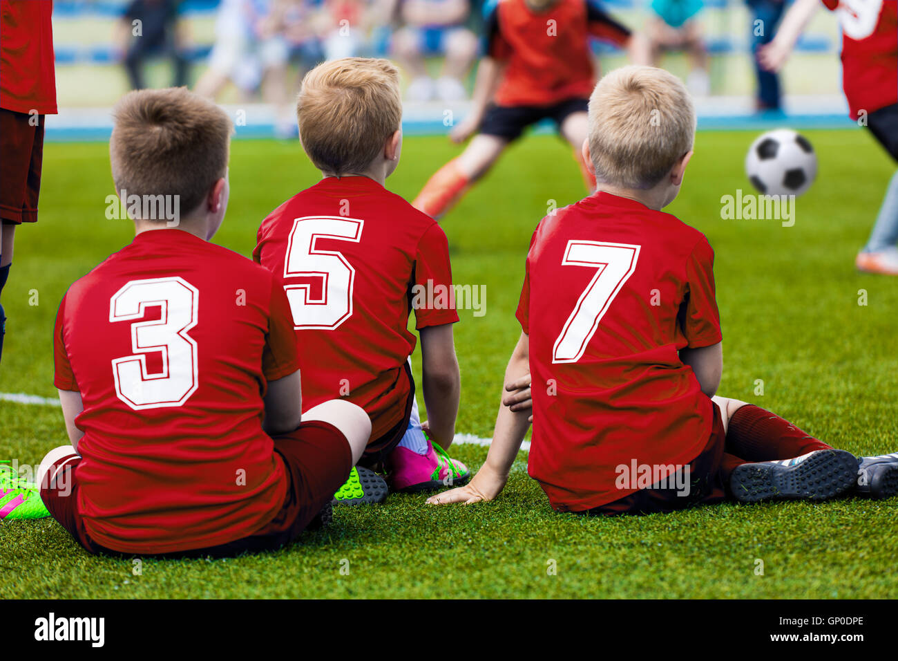 Youth soccer team on football pitch. Reserve players of red team ...