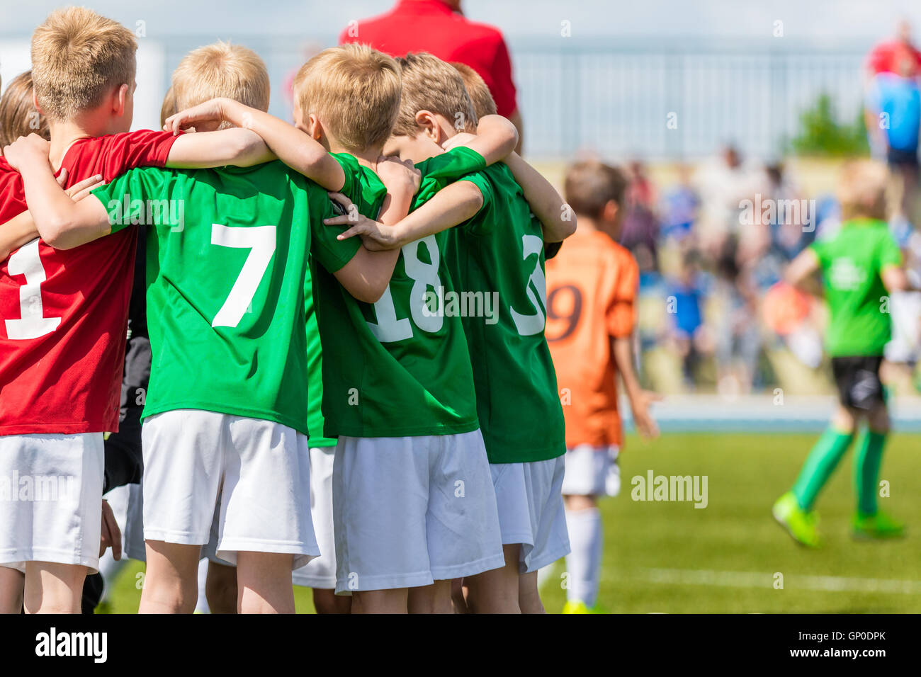 Kids on soccer field. Youth football team united, shout team before the ...