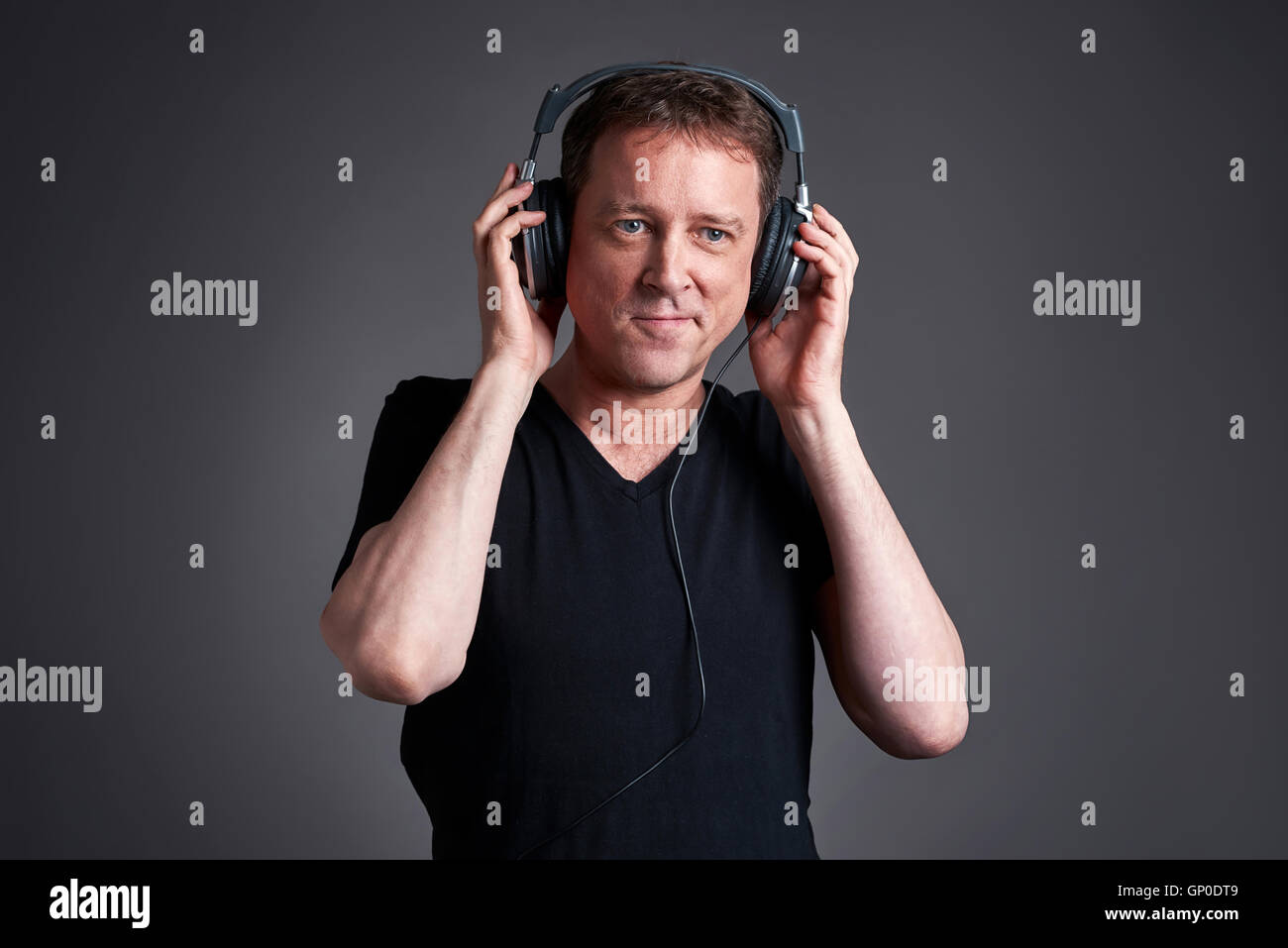 A middle age listening and enjoying some music on the headphone Stock ...