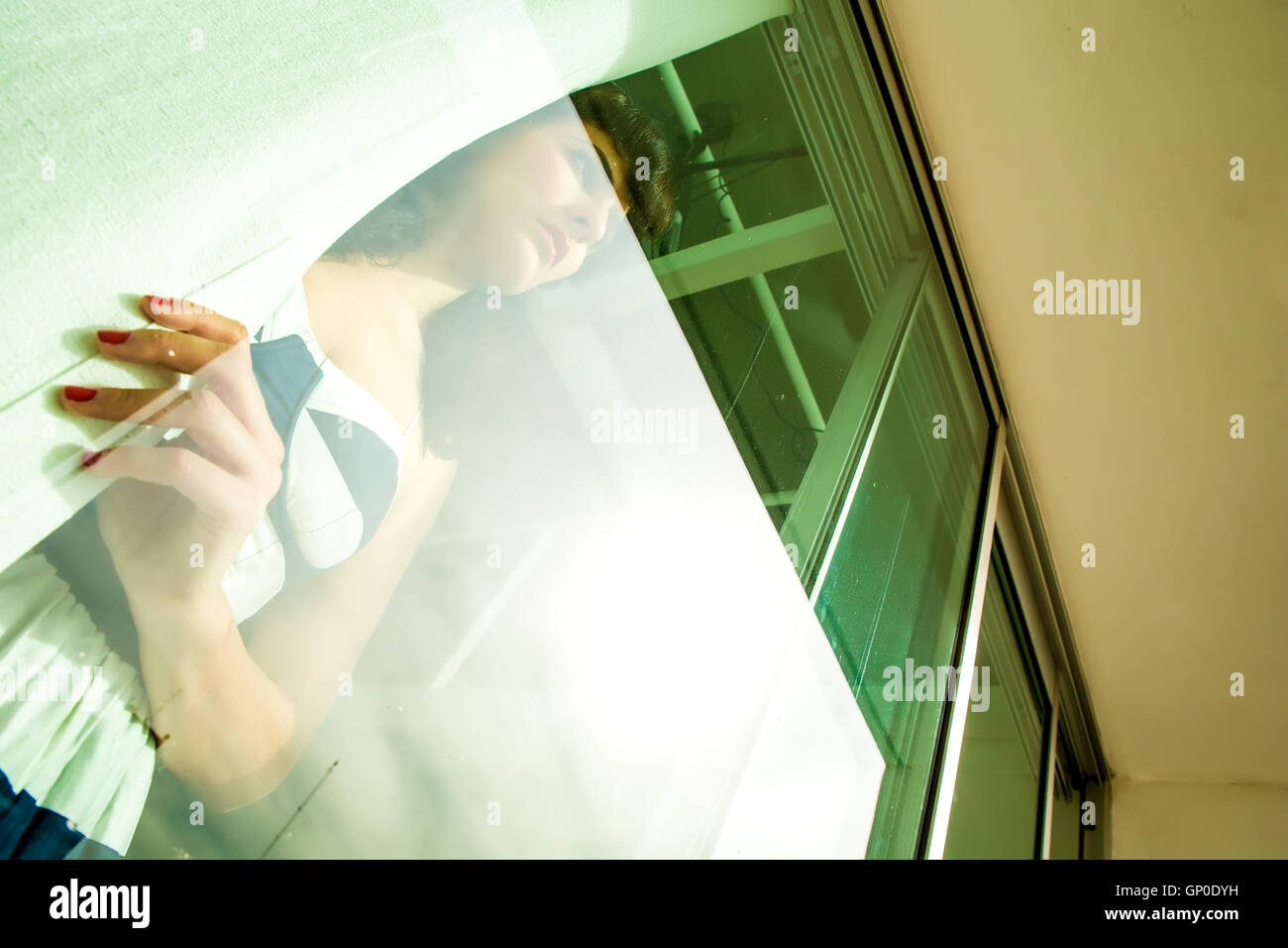A pensive vintage girl standing behind a window Stock Photo - Alamy