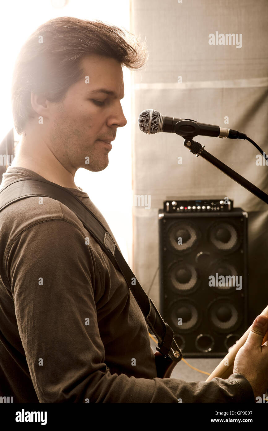 A Rock singer playing bass in the rehearsal Studio Stock Photo - Alamy