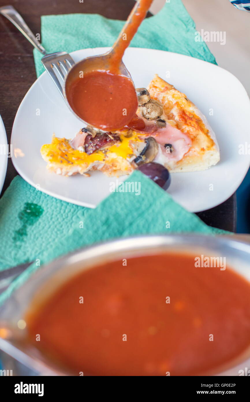 putting ketchup on pizza slice at the restaurant Stock Photo - Alamy