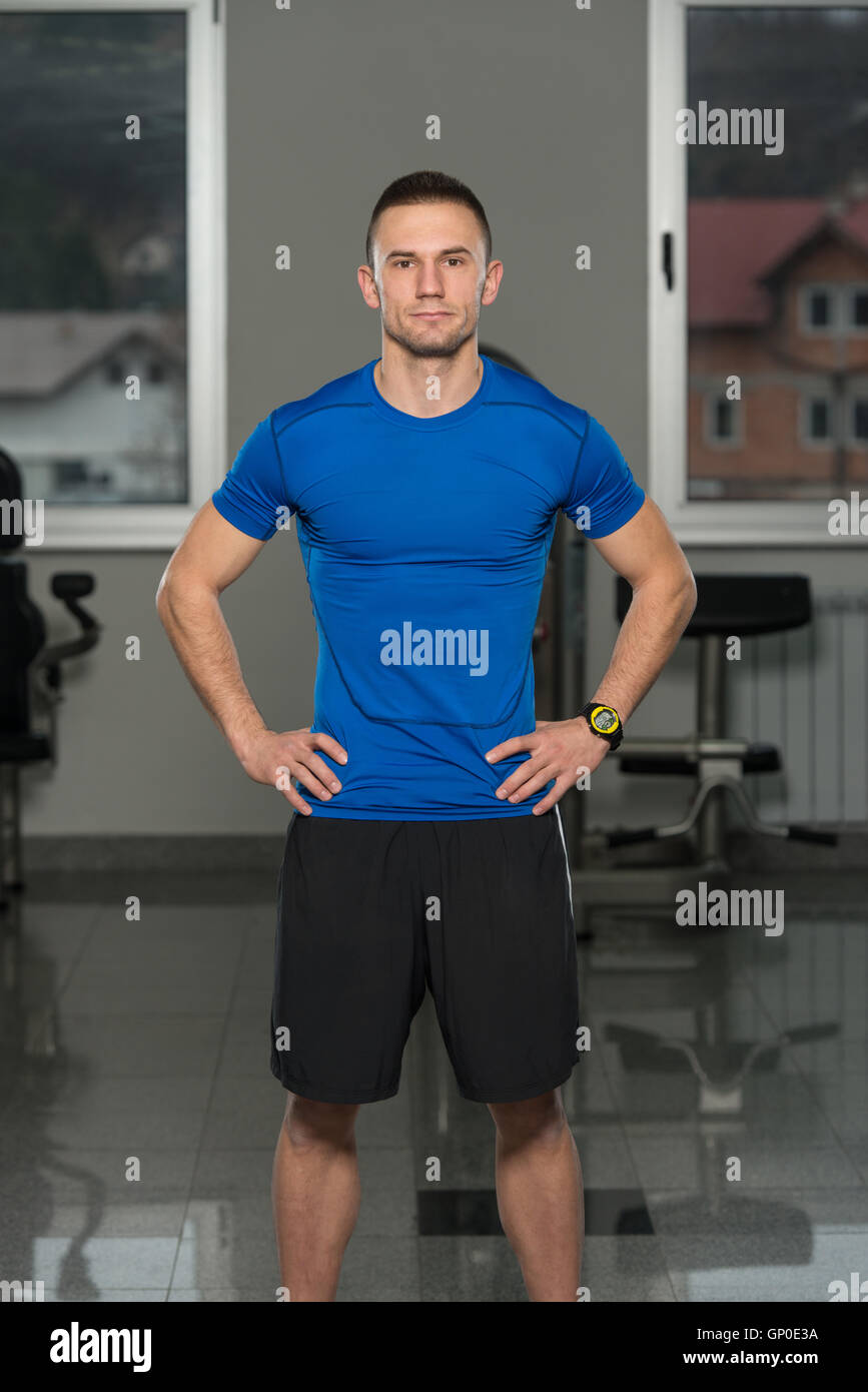 Personal Trainer In Sports Outfit In Fitness Center Gym Standing Strong ...