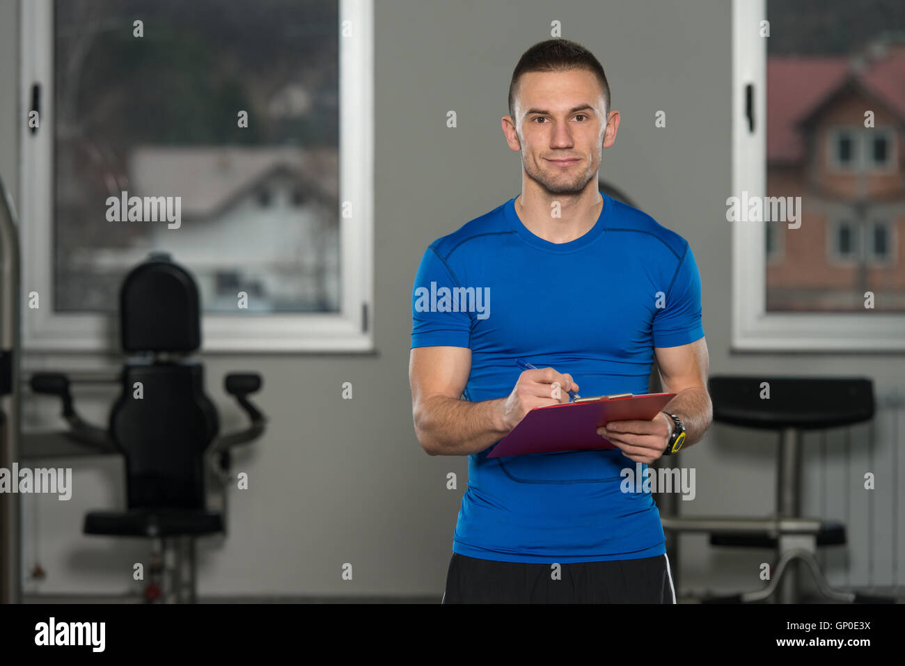Handsome Personal Trainer With A Clipboard In Fitness Center Gym Stock ...