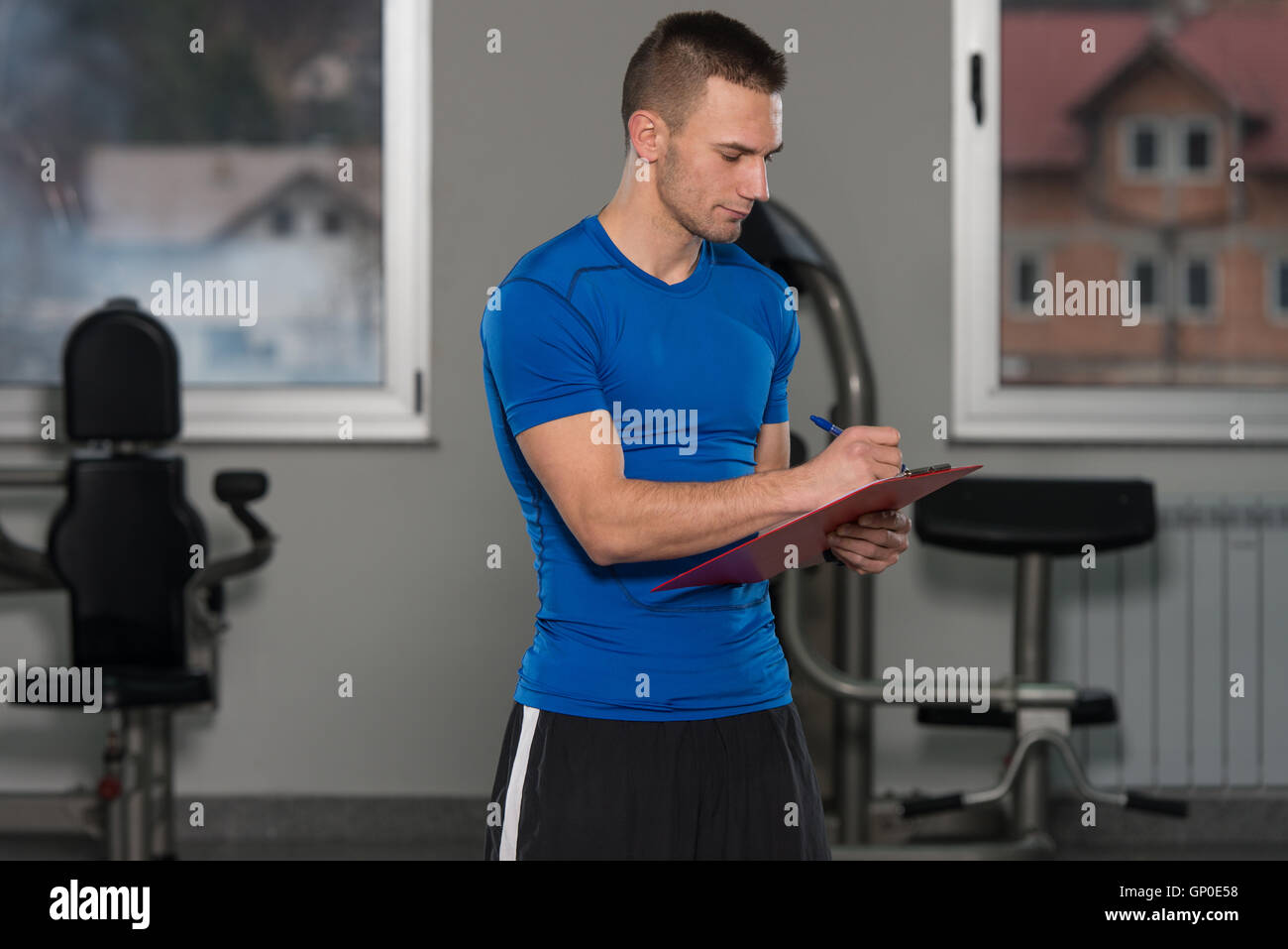 Personal Trainer Takes Notes On Clipboard In Fitness Center Gym Stock ...