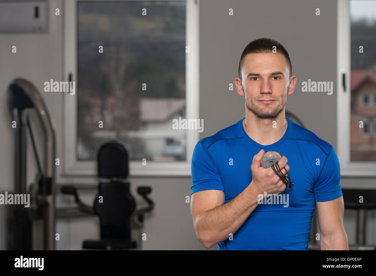 Handsome Personal Trainer With Stopwatch In A Fitness Center Gym ...