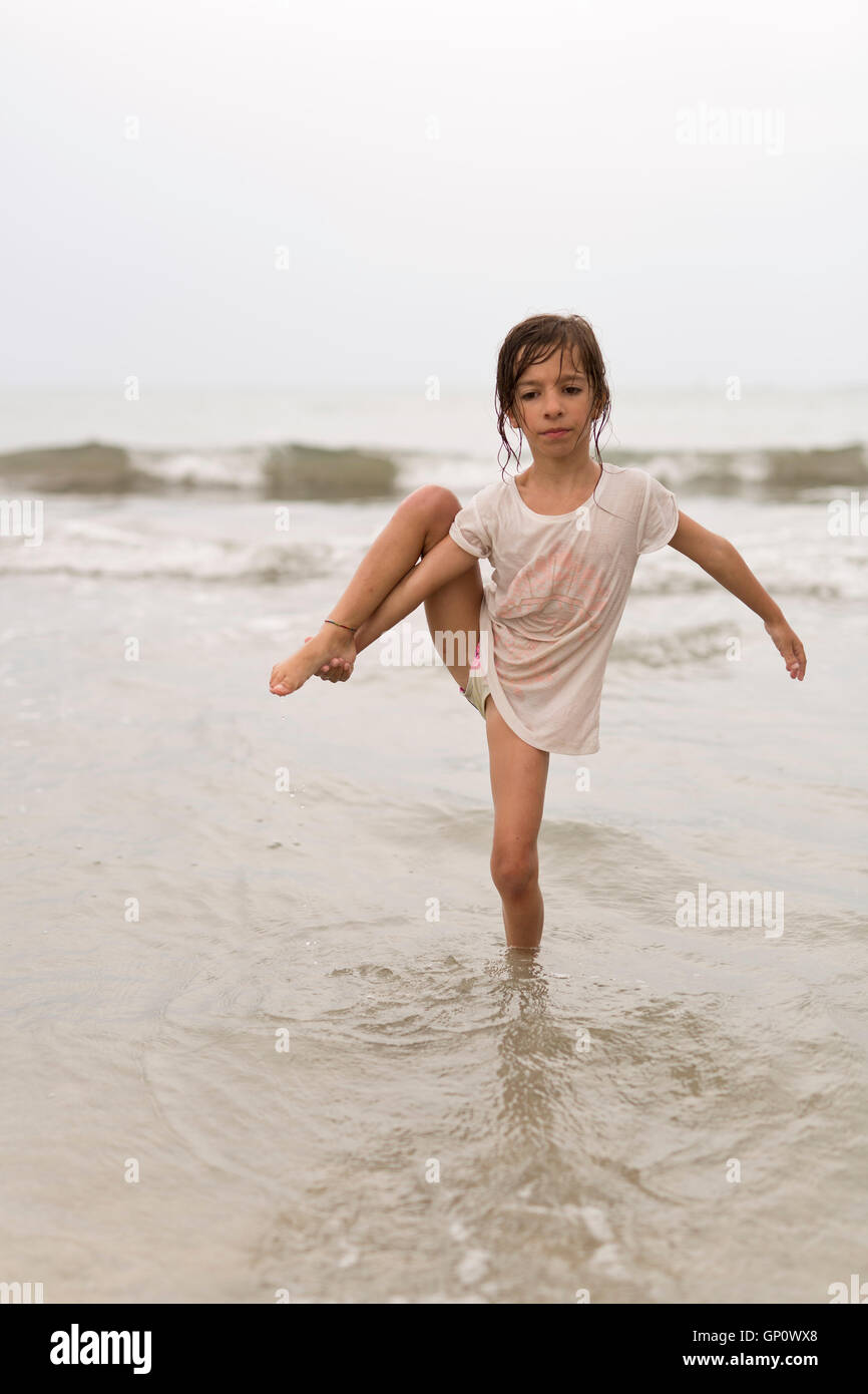 Little girl on a beach doing water gymnastics Stock Photo - Alamy