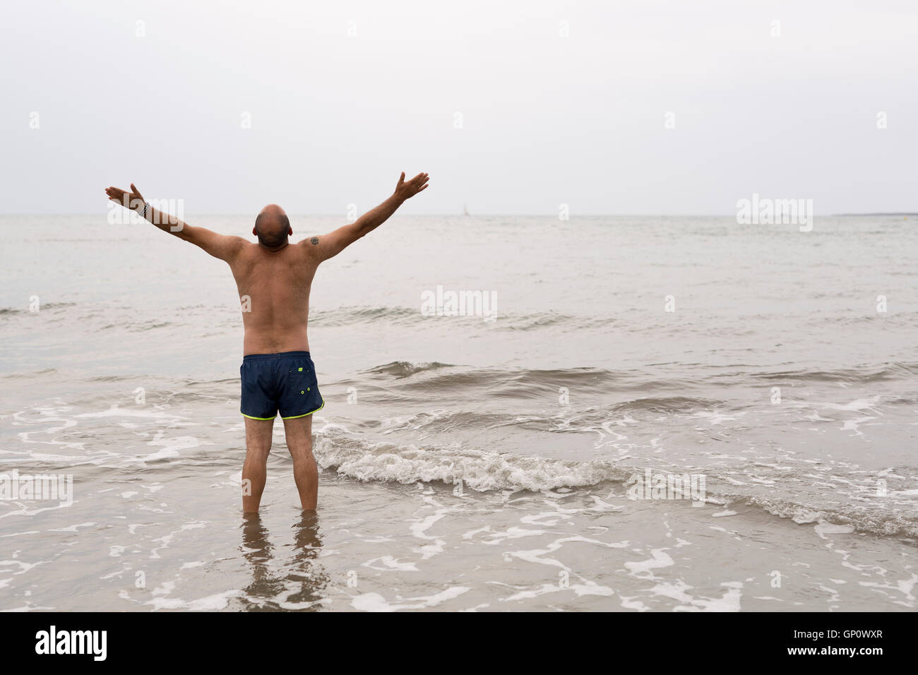 Man on the beach with open arms as a sign of freedom Stock Photo - Alamy