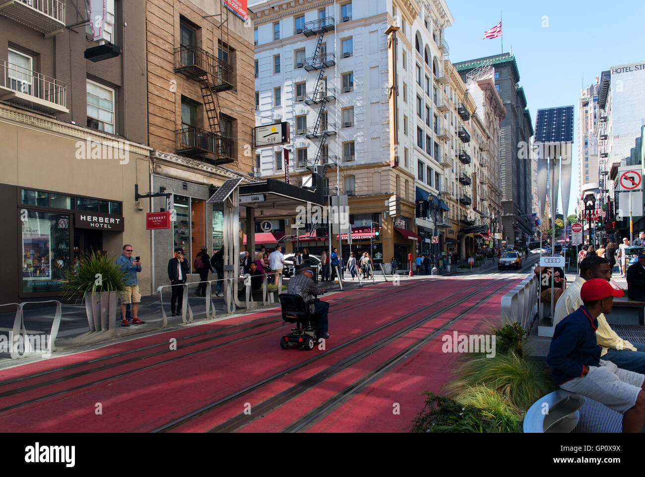 Man on an electric wheelchair going down the street in Downtown San ...