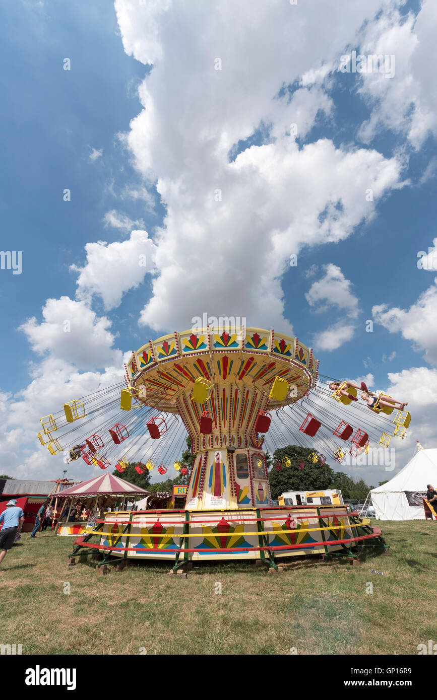Young people enjoying ride on flying chairs fairground ride at Stow cum ...