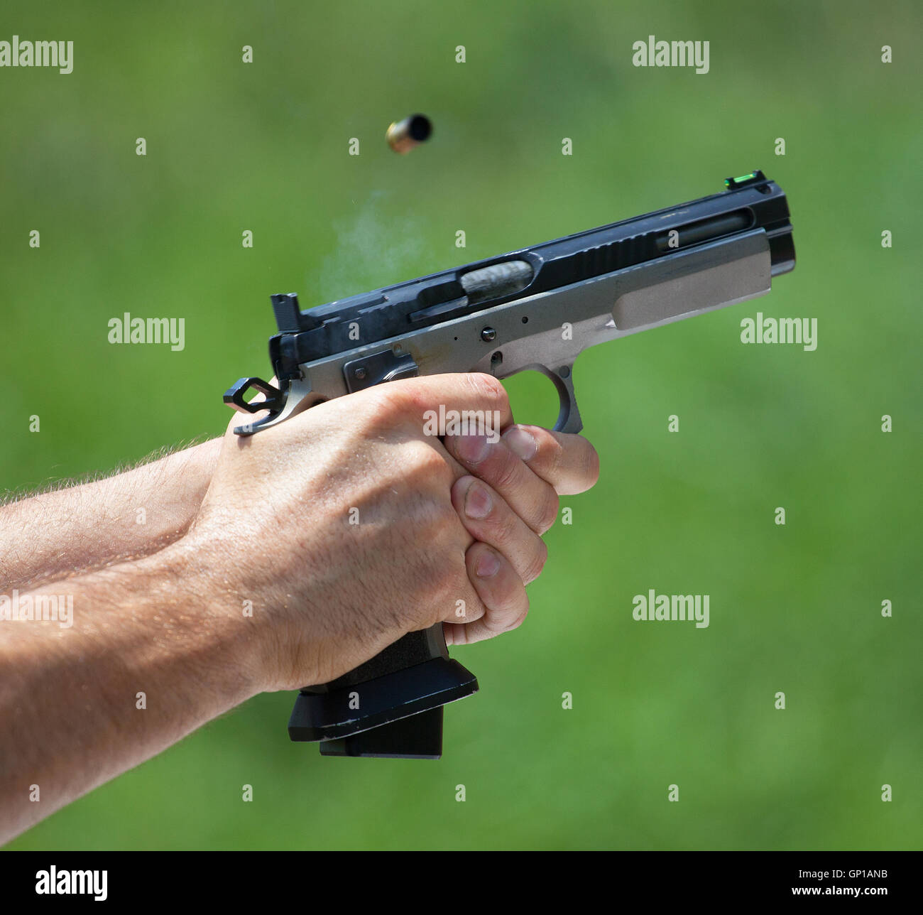 Brass as it is being ejected from a handgun Stock Photo - Alamy