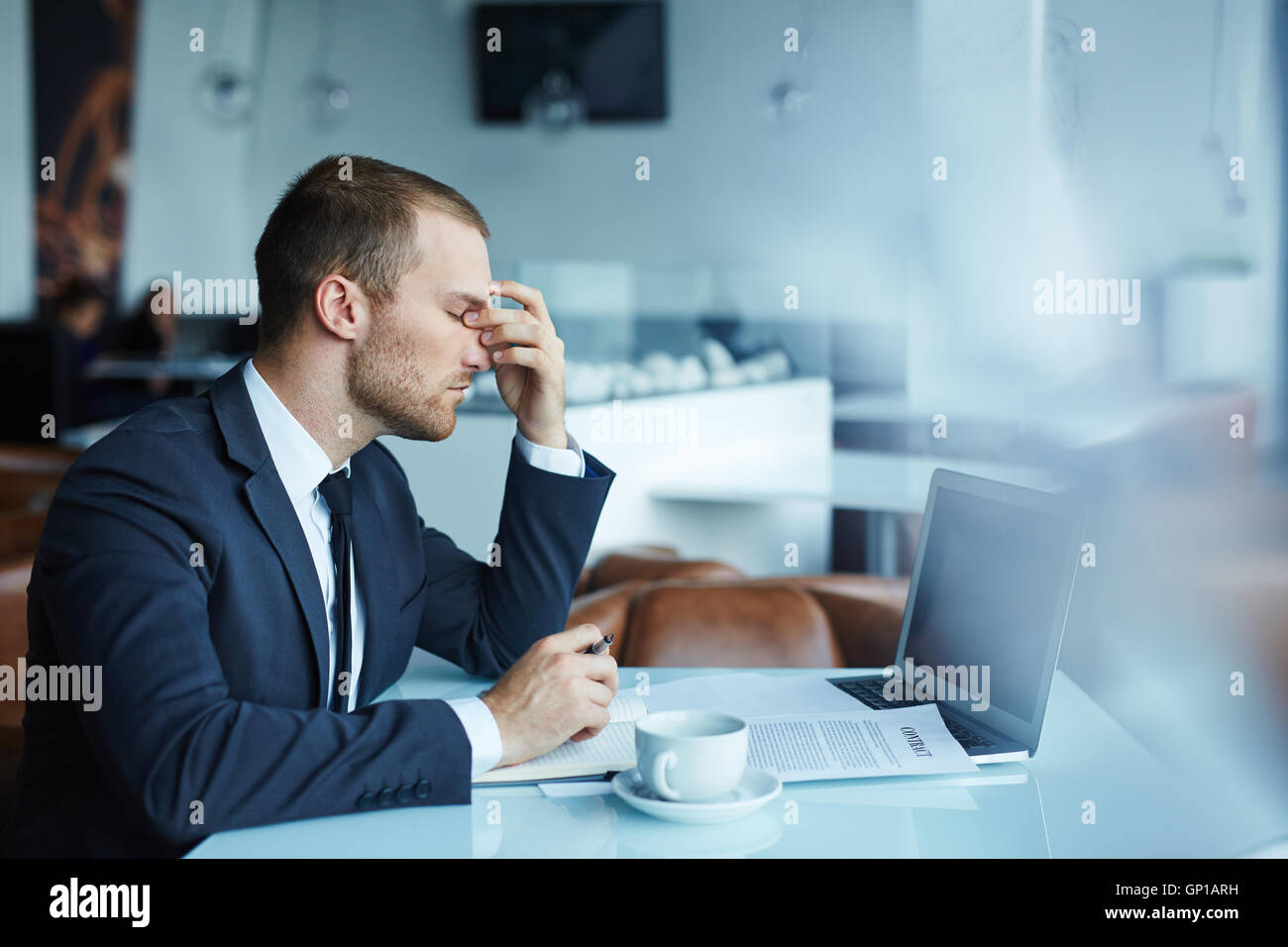 Overworked businessman sitting in front of laptop and planning work ...