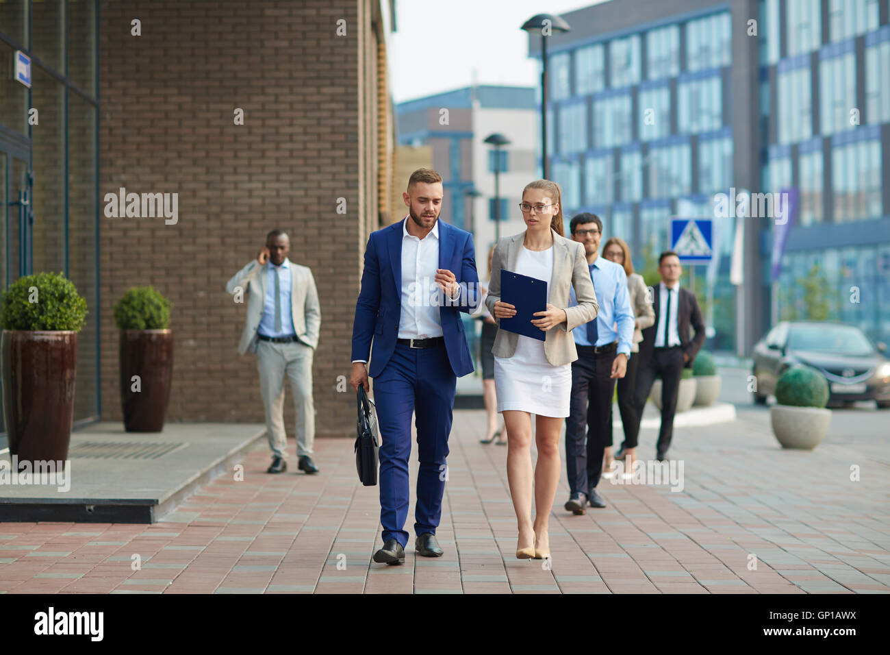 Two colleagues interacting while walking to work Stock Photo - Alamy