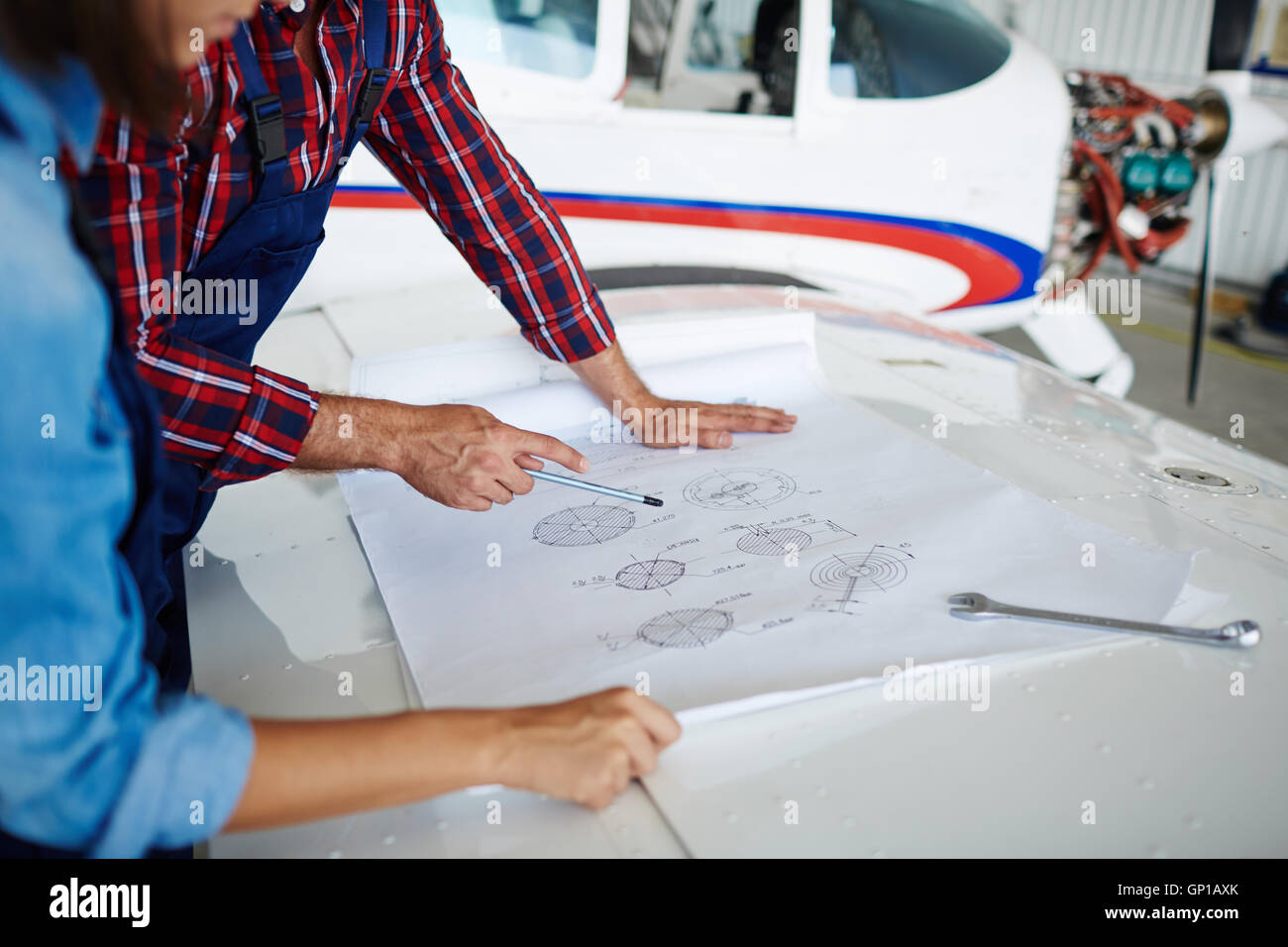 Two mechanics discussing sketch of parts Stock Photo - Alamy