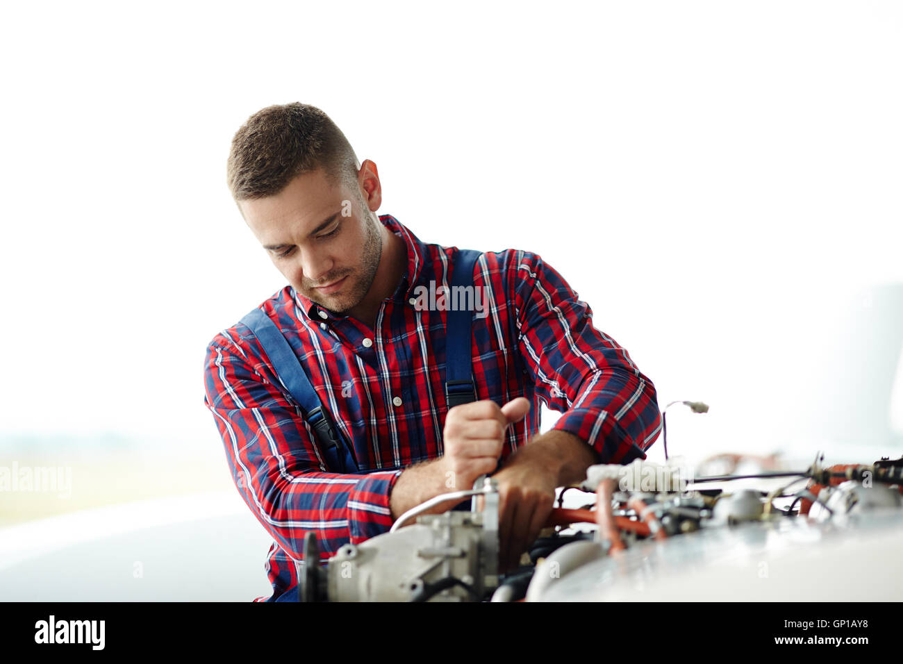 Young repairman fixing engine parts Stock Photo - Alamy