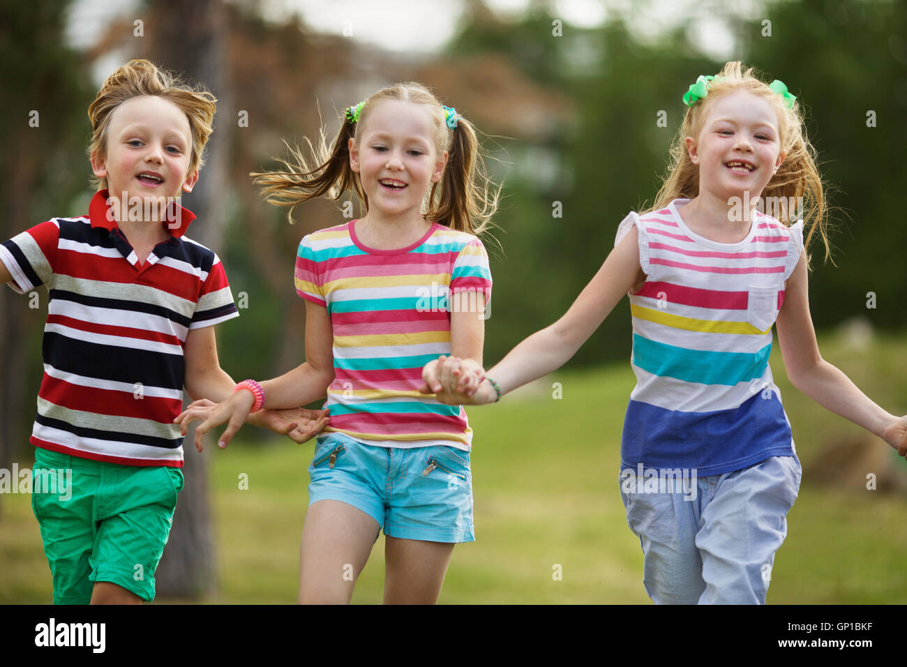 Three carefree kids running outdoors Stock Photo - Alamy