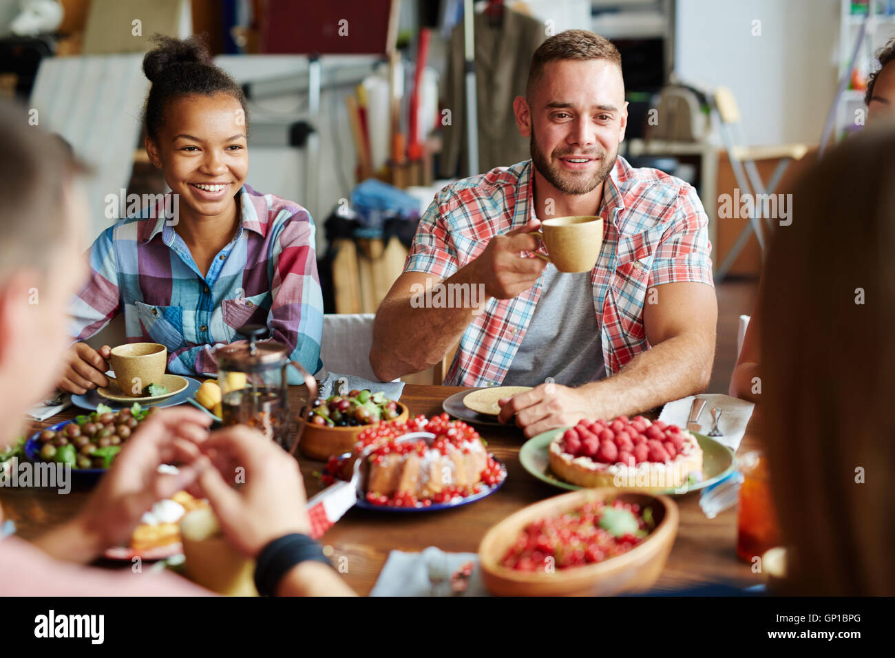 Friendly young people talking by dinner Stock Photo - Alamy