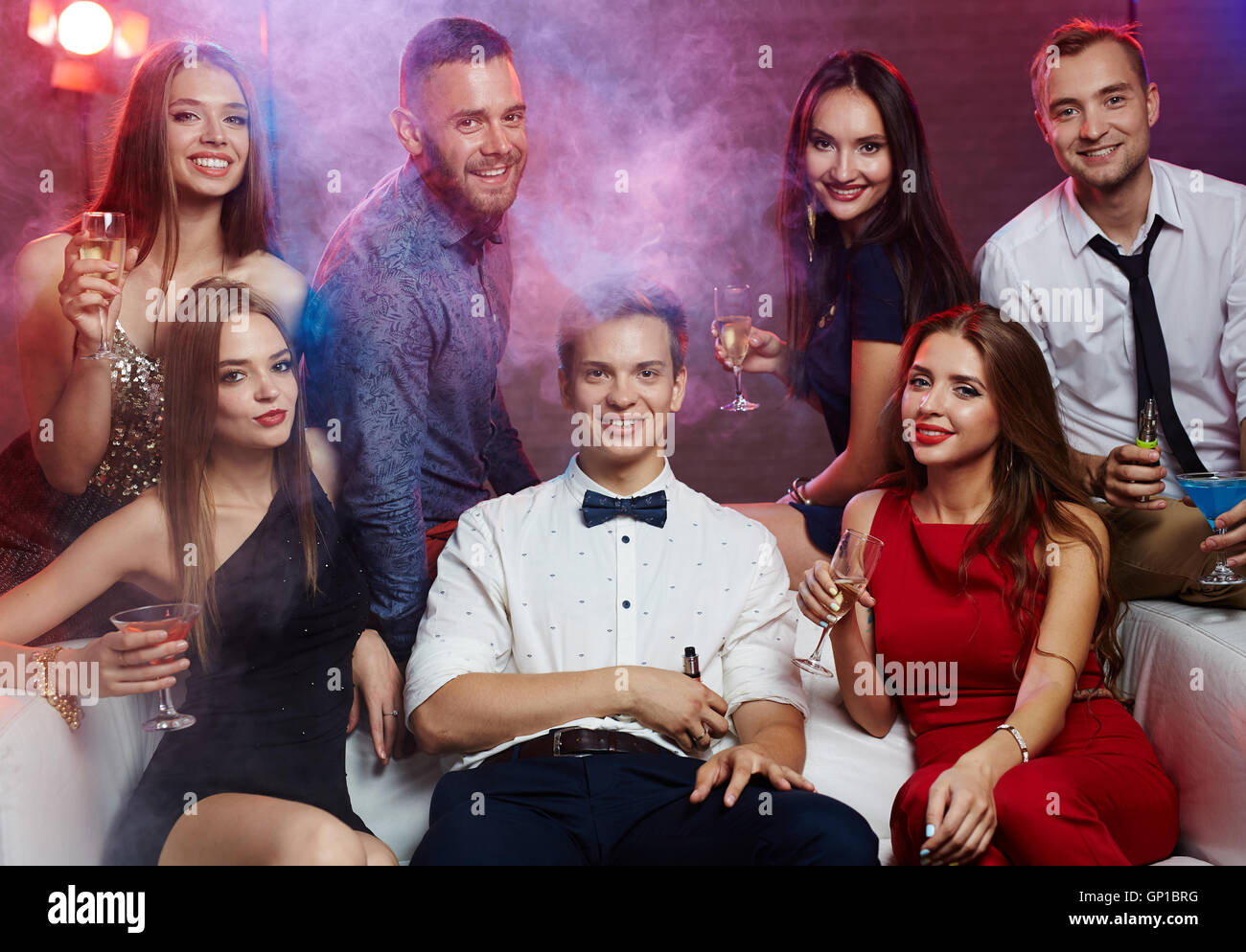 Group of clubbers with drinks sitting in night club Stock Photo - Alamy