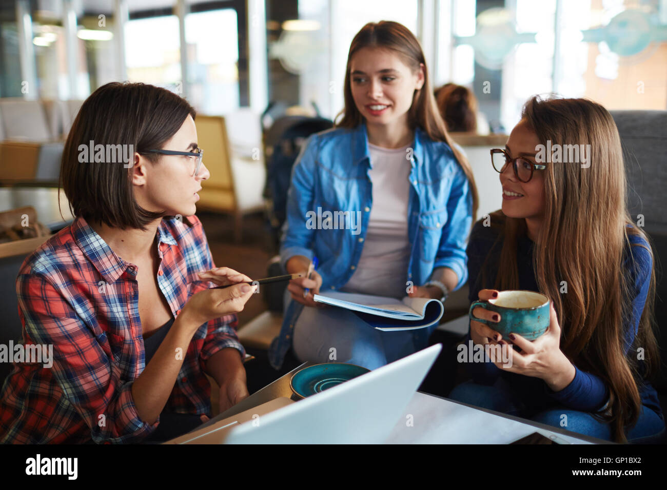 Three friendly students interacting after college classes Stock Photo ...