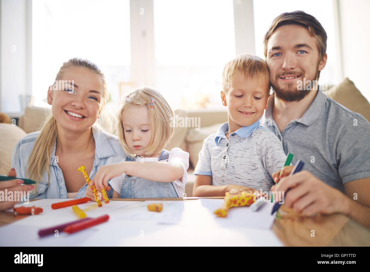 Young married couple drawing with their two kids, enjoying time ...