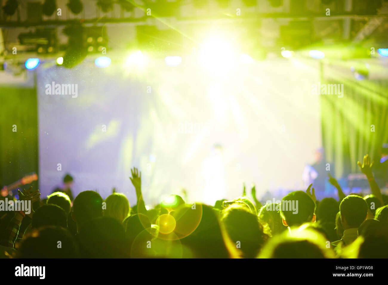 Excited youth crowd cheering in front stage at music concert with ...