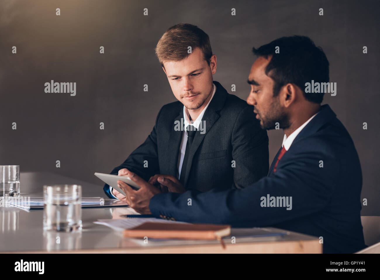 Comparing digital notes in the boardroom Stock Photo - Alamy