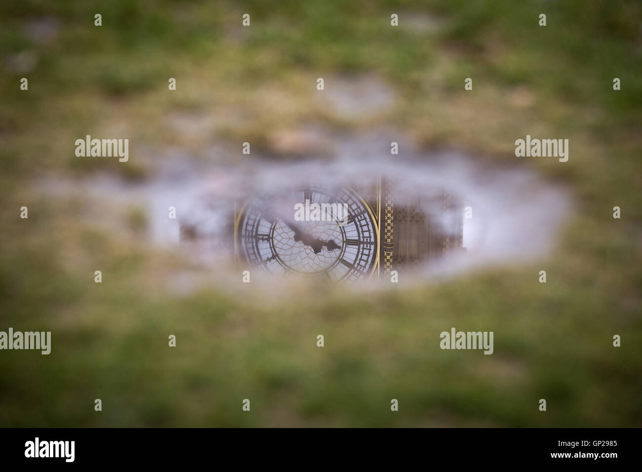 Big Ben of the Houses of Parliament is reflected in a puddle in ...