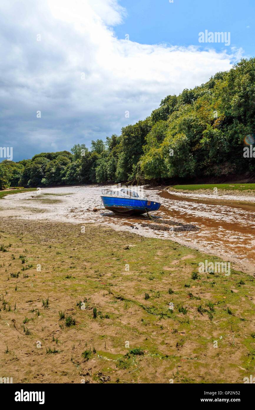 A single blue and white boat in the River Gannel estuary near Newquay ...