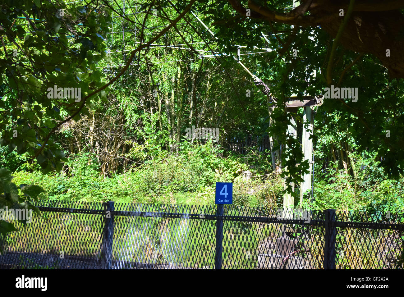 4 Car Stop sign next to train line with barrier and overhead cables in ...