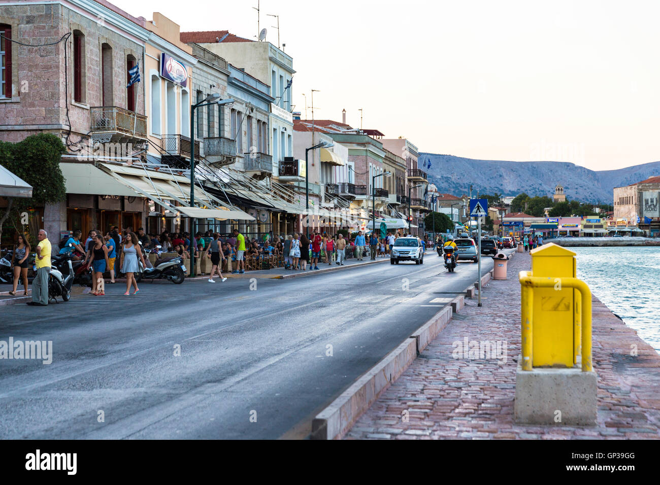 People walking and sitting on the coastline of Chios island city center ...