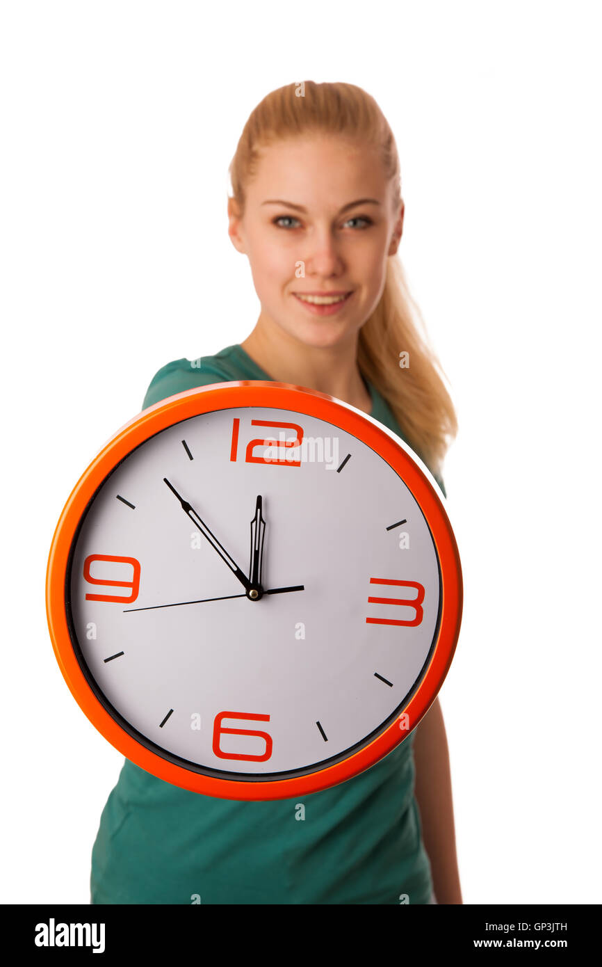 Blonde woman holding big clock in hand, smiling because it is almost ...